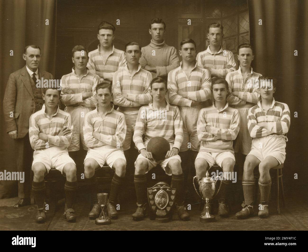 Unidentified football team showing trophies, 1930s Stock Photo - Alamy