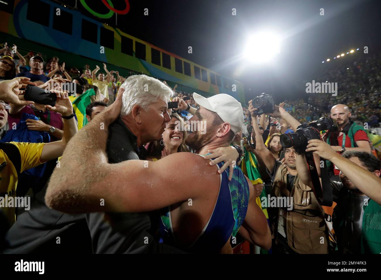 Brazil's Alison Cerutti, center, gets a hug from former beach ...
