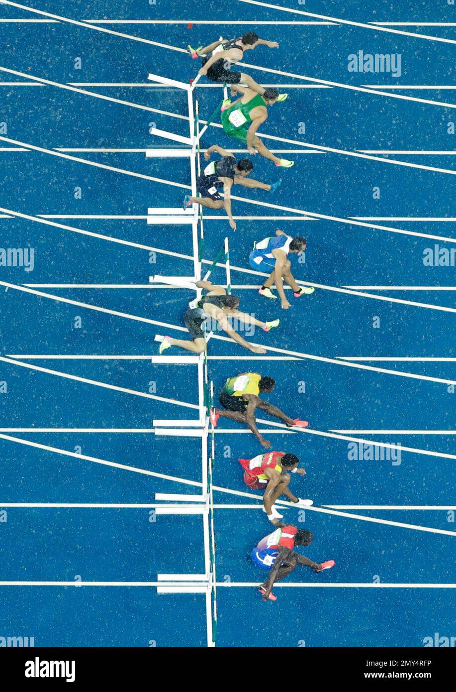 Runners compete in a 110 meter hurdles heat during the athletics ...