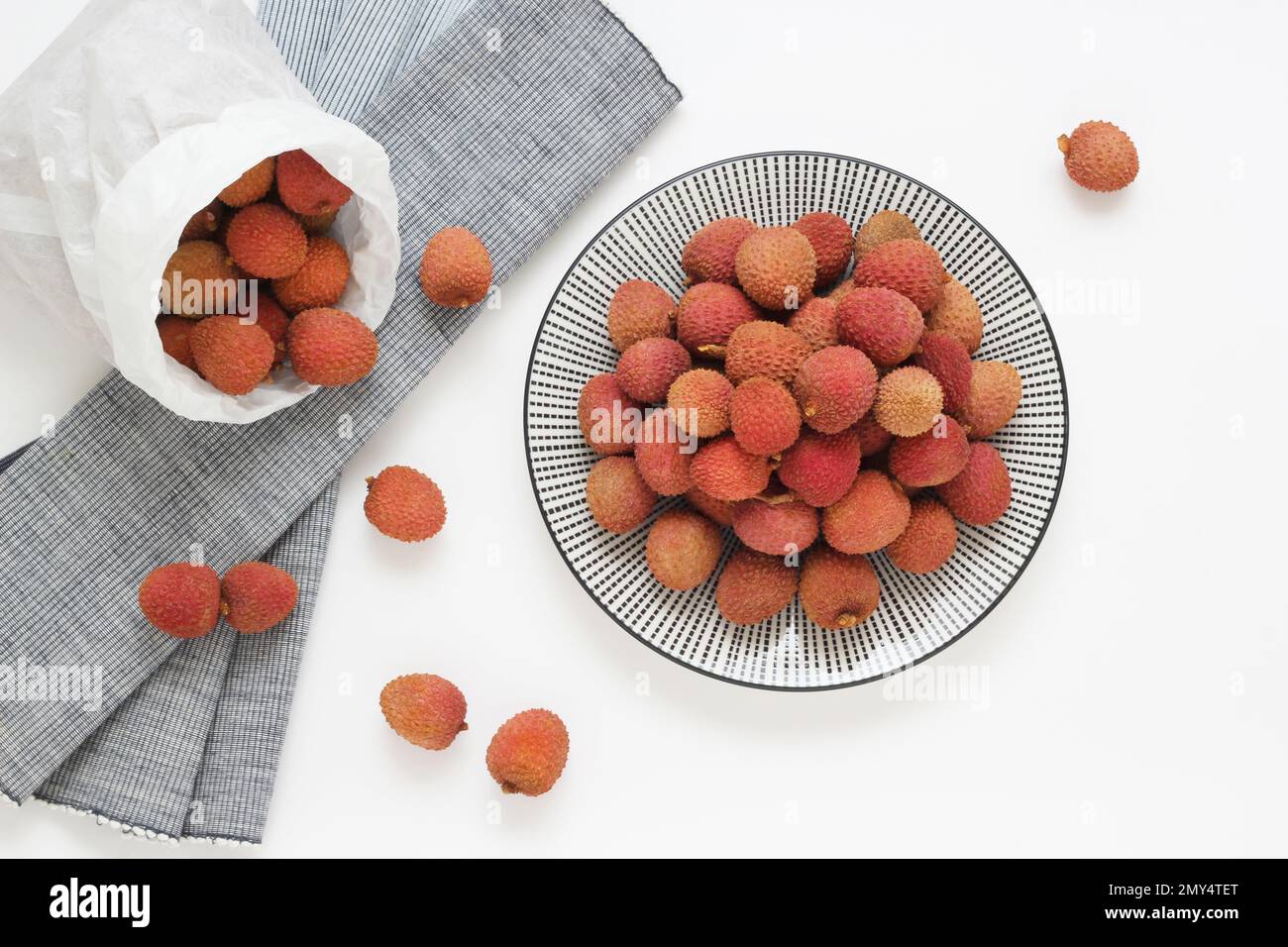 Lychee fruit on Asian plate on white background with whole pieces ...