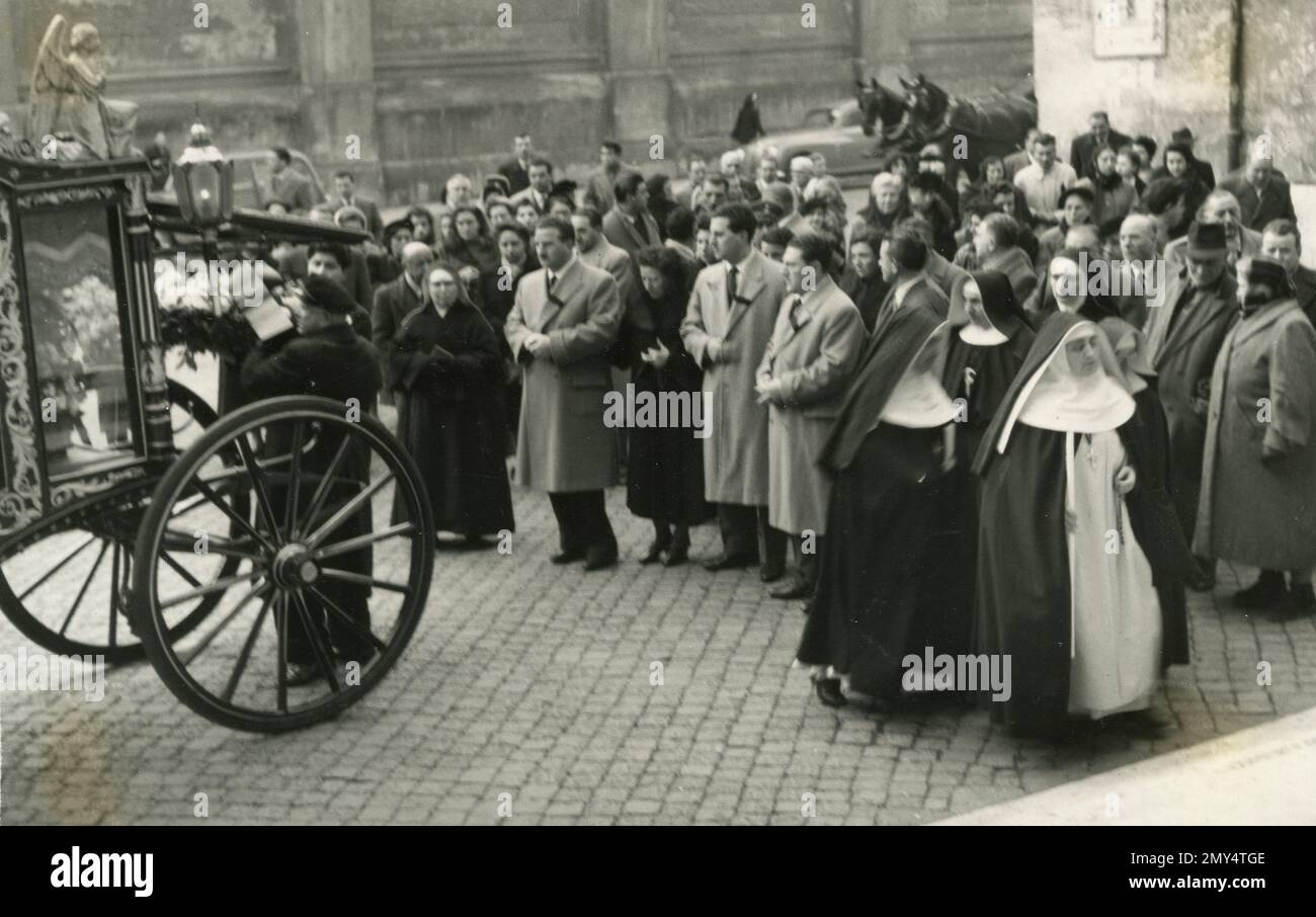 Traditional Italian catholic church funeral with wagon, procession and ...