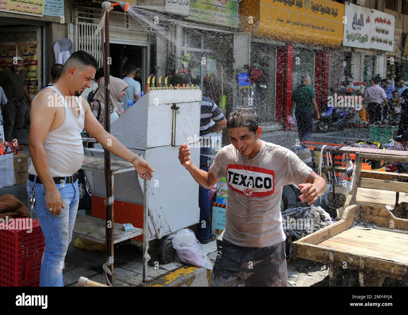 People cool off from the summer heat by using an open air shower in ...