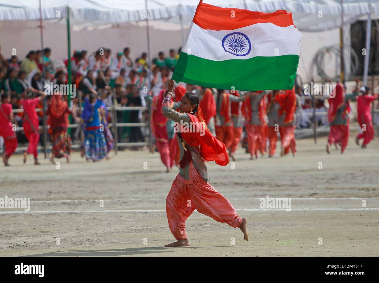 A student holds the Indian national flag as she performs a dance during ...