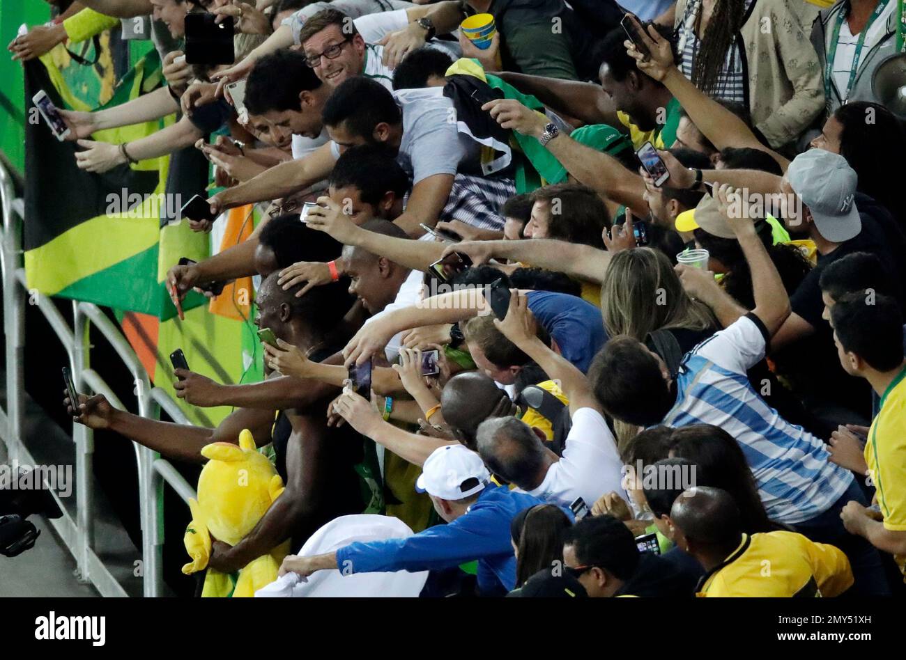 Jamaica's Usain Bolt, left, greets spectators after winning the men's ...