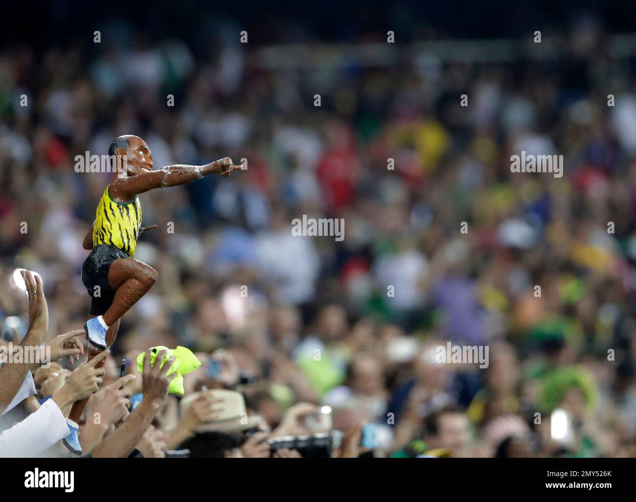 A spectator holds up a puppet of Jamaica's Usain Bolt during the ...