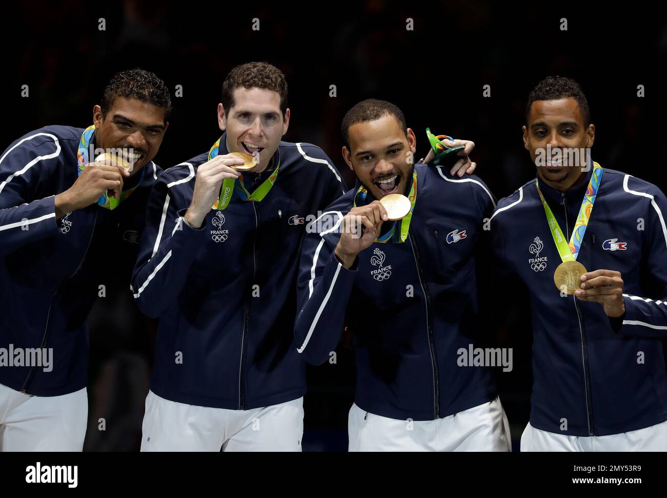 Fencers of the French team celebrate biting their gold medals after ...