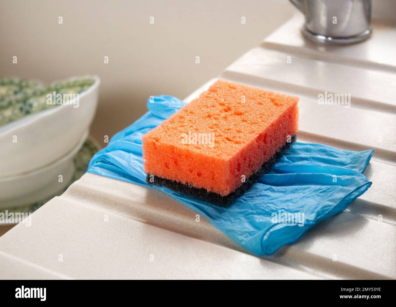 Sponge for washing dishes and rubber gloves lying on sink in kitchen ...