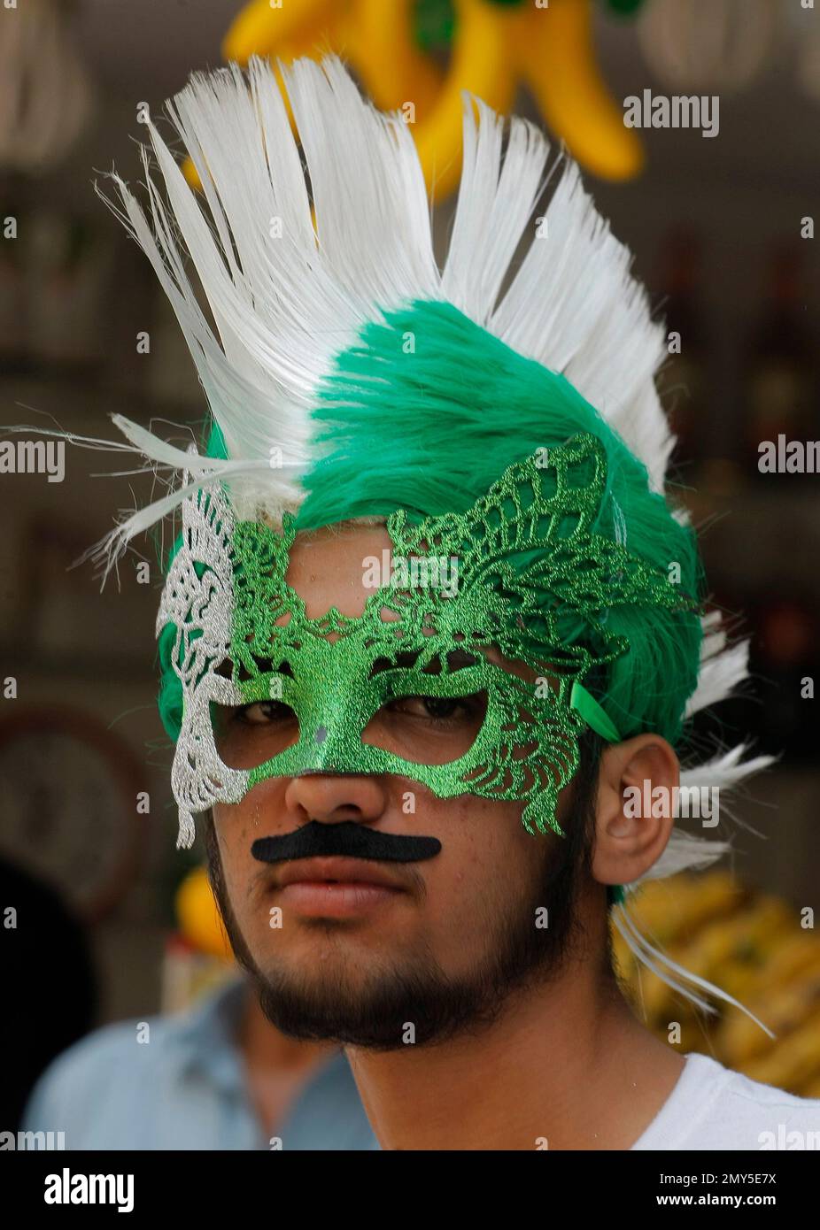 A Pakistani youth wears a mask painted with the colors of the national ...