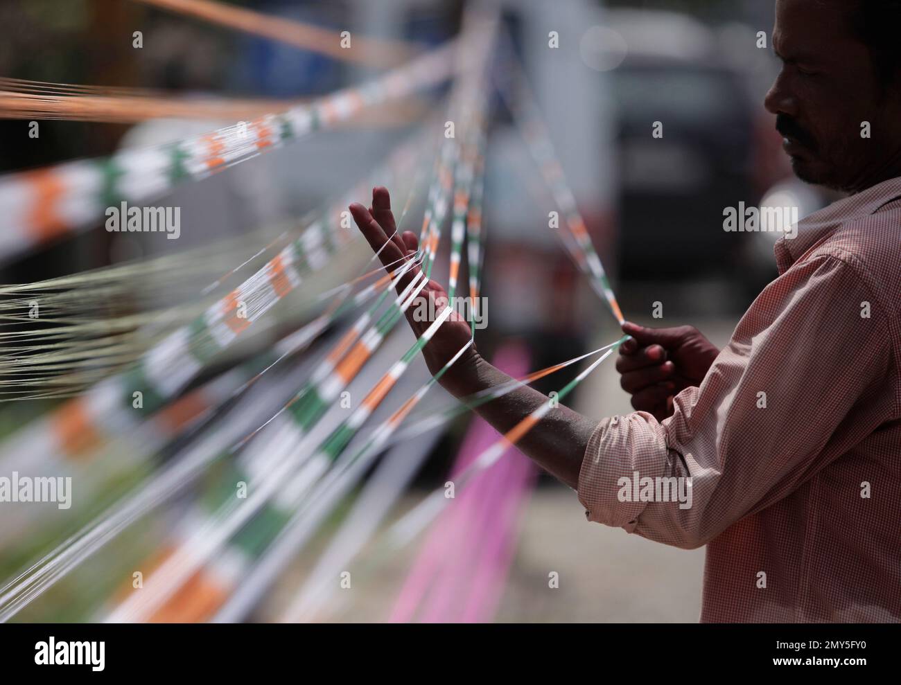 A professional thread maker prepares threads with the three colors of ...