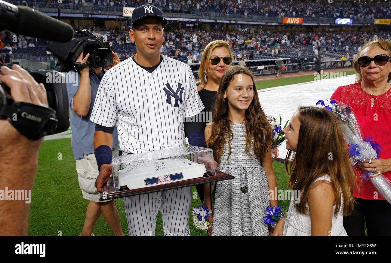 New York Yankees' Alex Rodriguez holds a signed base as he stands with his mother, Lourdes ...