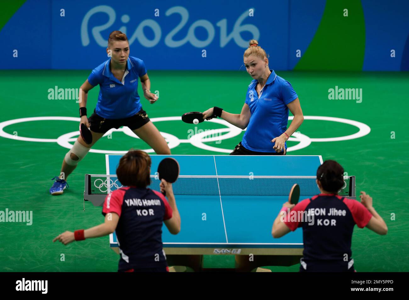 Daniela Monteiro Dodean hits the ball next to Bernadette Szocs of ...