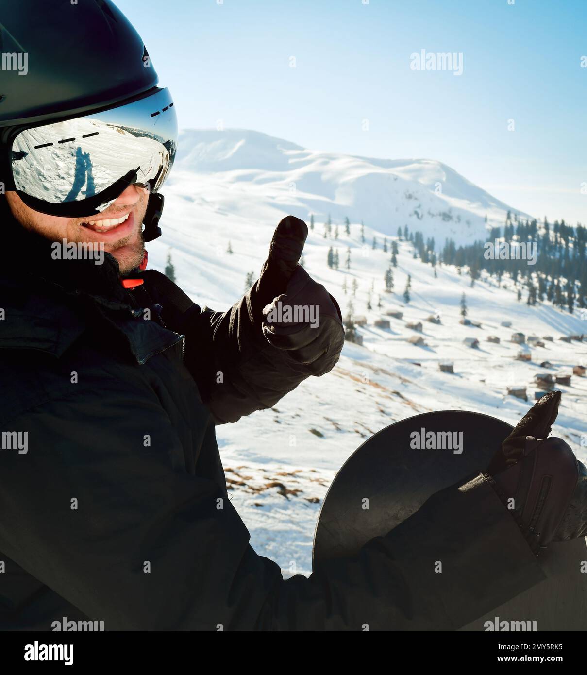 Freerider snowboarder smiling to the camera, showing thumb up, standing ...