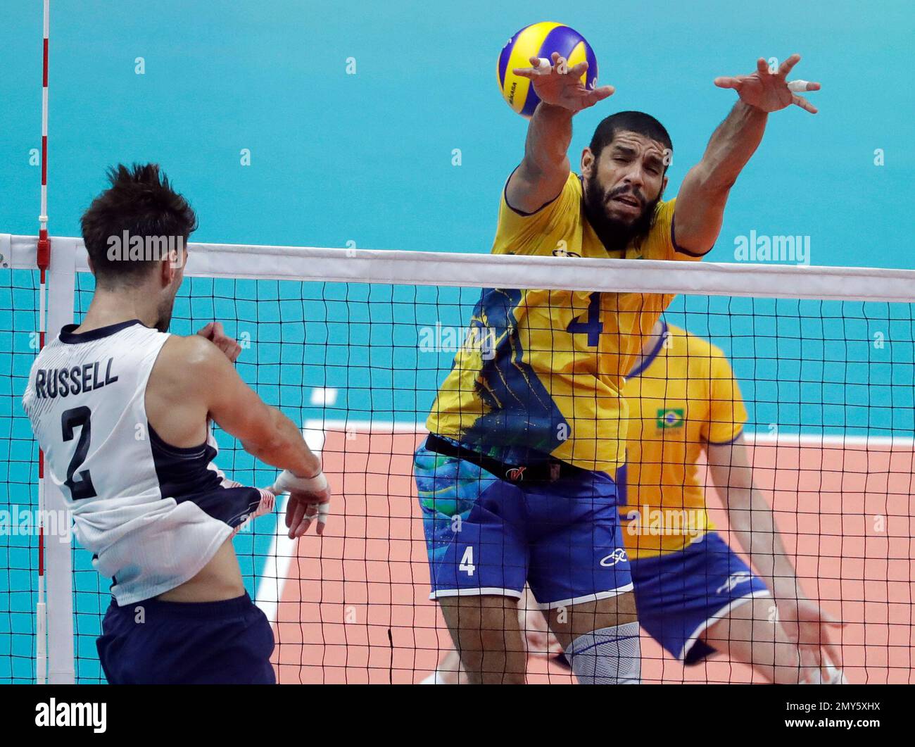 United States' Aaron Russell, left, spikes the ball past Brazil's ...