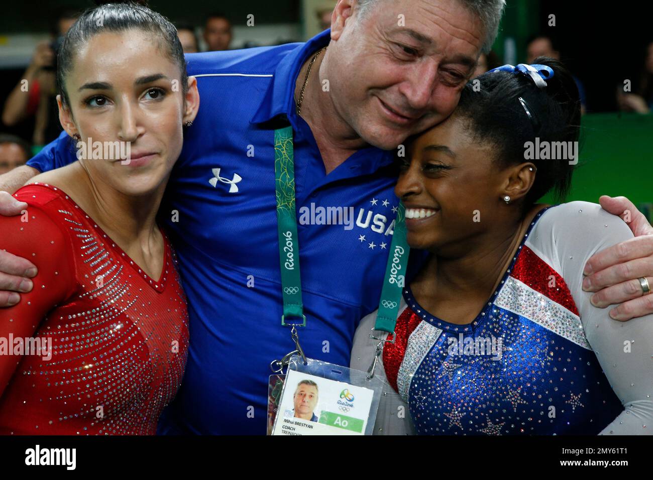 United States' Simone Biles, right, and Aly Raisman embrace coach Mihai ...