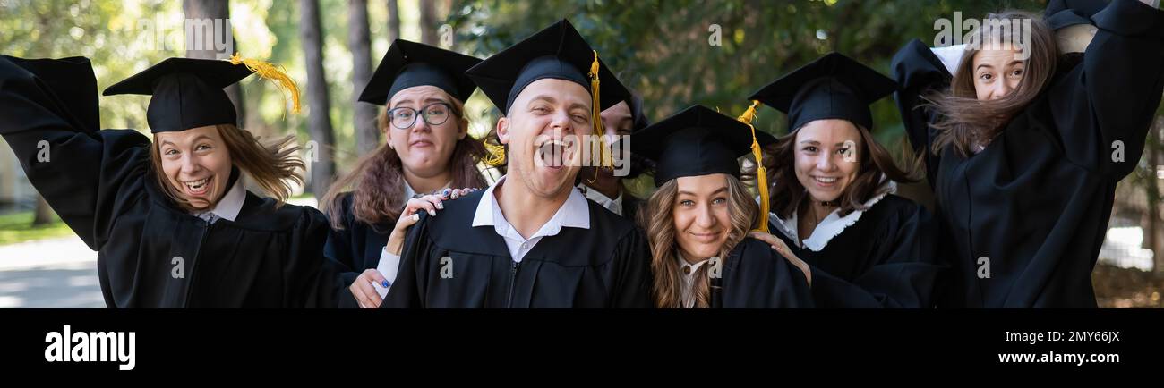 A group of graduates in robes congratulate each other on their ...