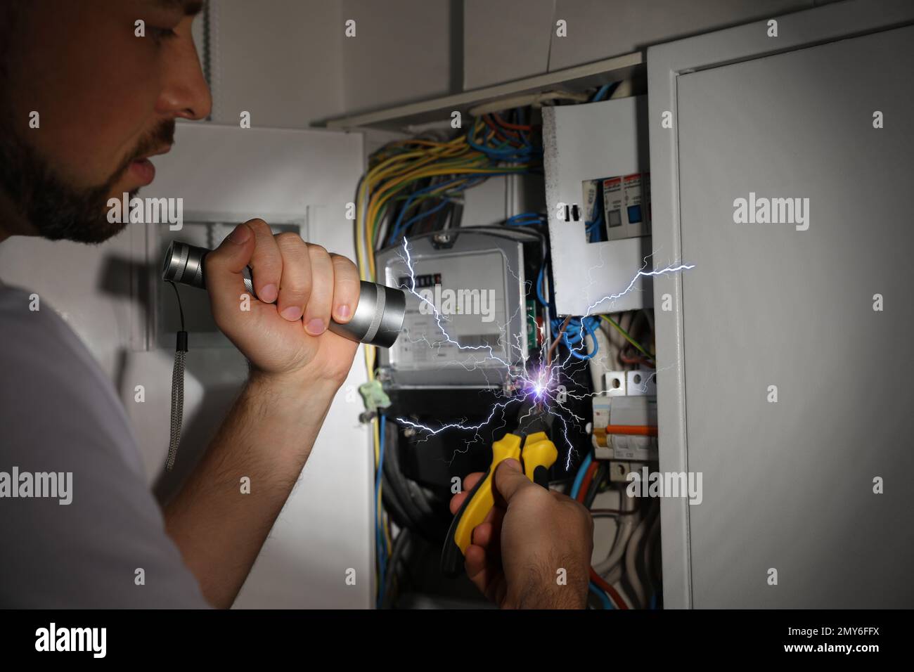 Electrician receiving electric shock while working, closeup Stock Photo ...