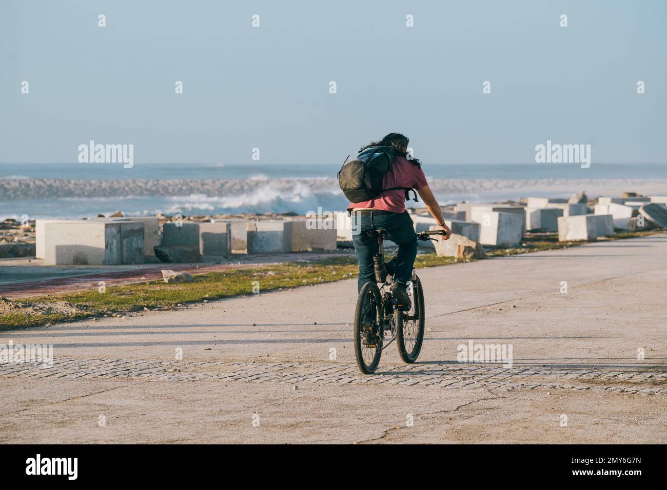 Bicycle touring along the promenade on the wavy blue sea shore Stock ...
