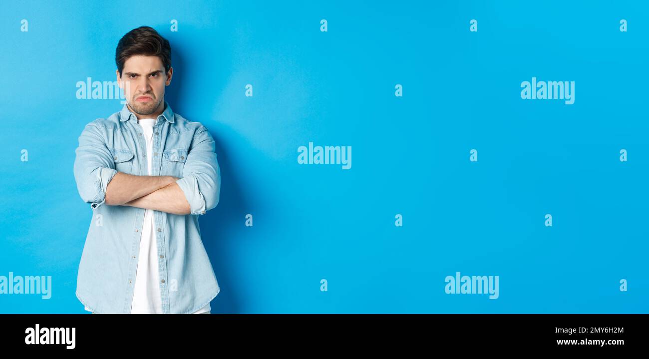 Angry bearded guy crossing arms on chest, frowning, looking mad and ...