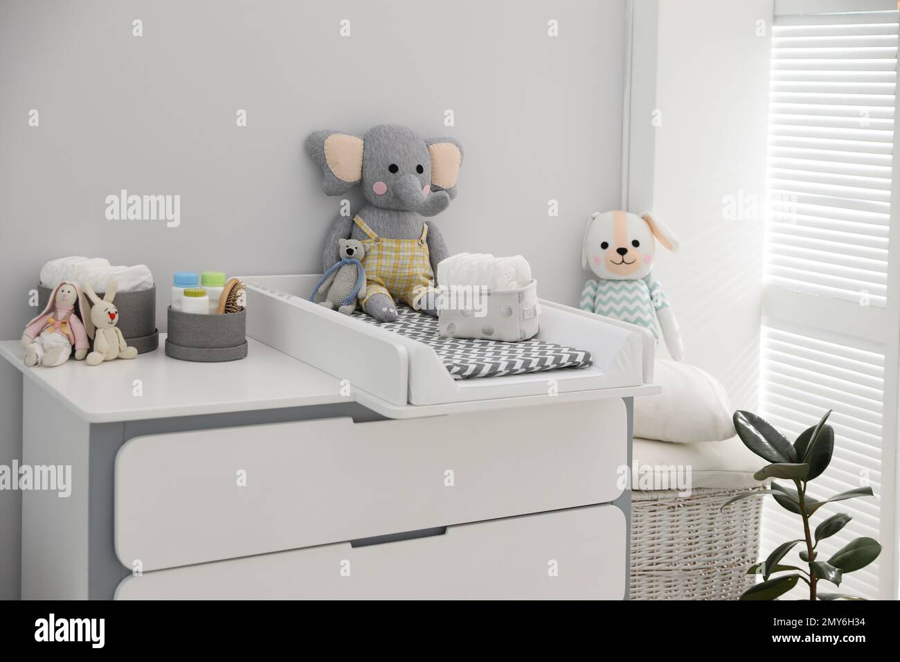 Changing tray and pad on chest of drawers in baby room. Interior design ...