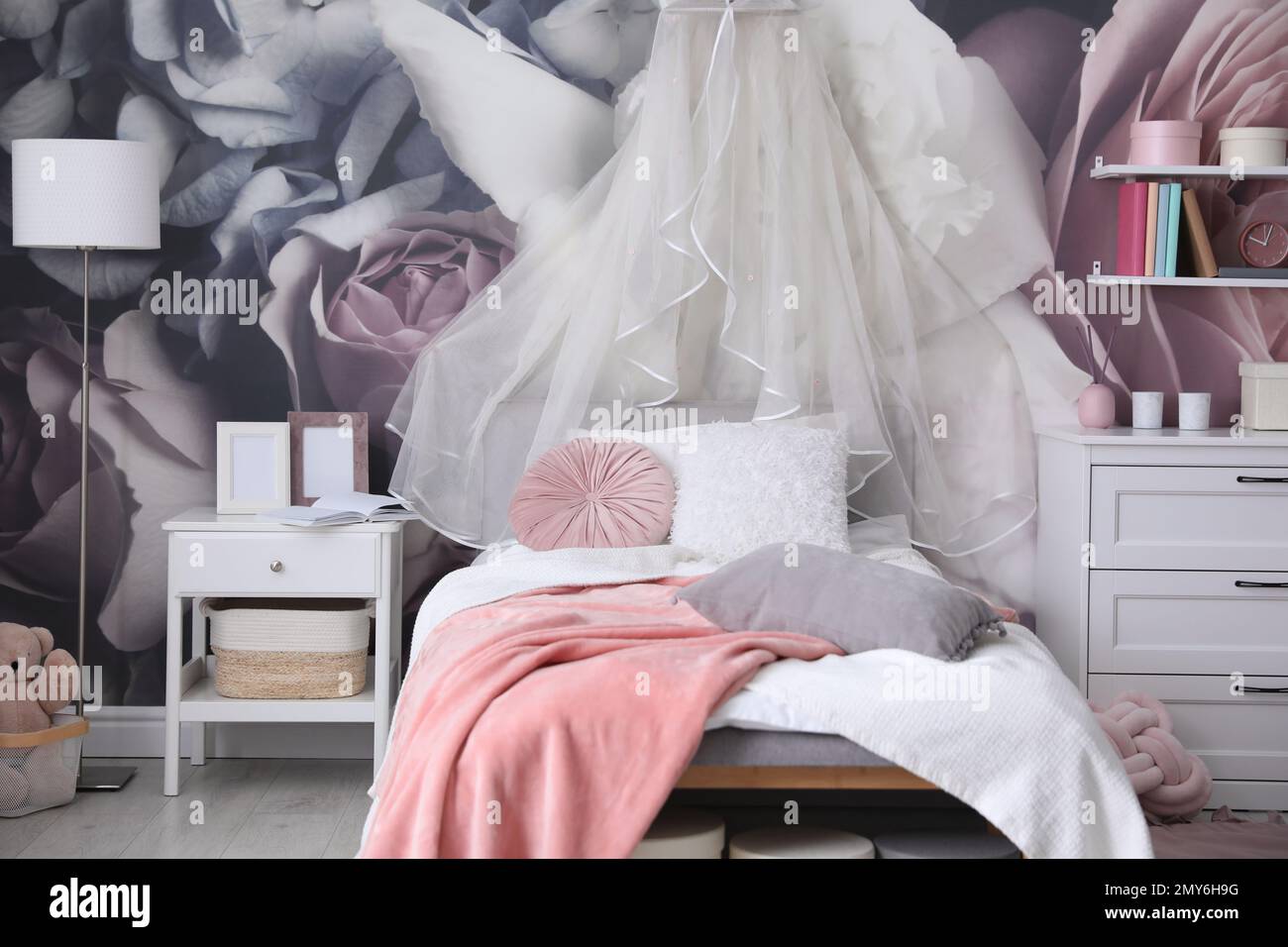 Teenage girl's room interior with comfortable bed and floral wallpaper ...