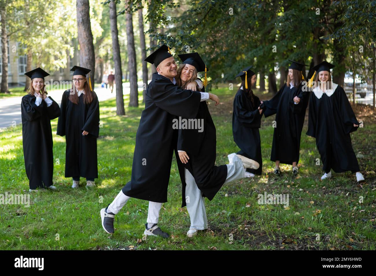 A group of graduates in robes congratulate each other on their ...