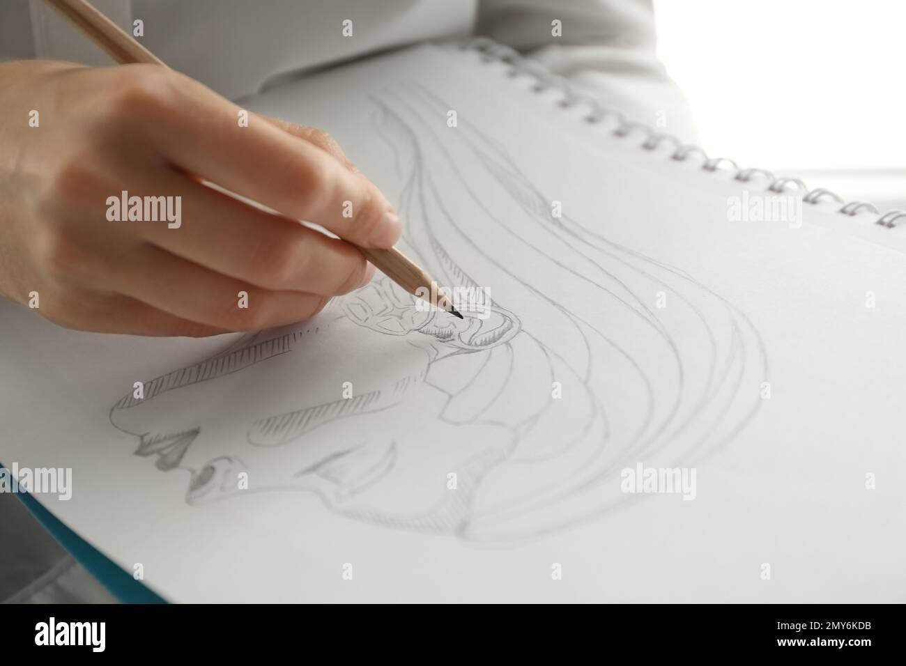 Woman drawing girl's portrait with pencil in notepad, closeup Stock ...