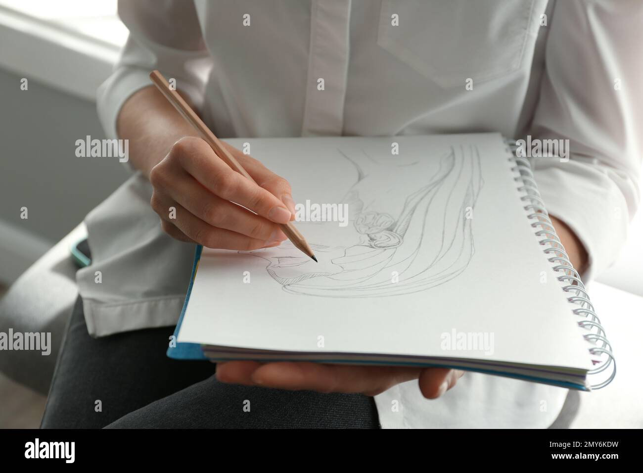 Woman drawing girl's portrait with pencil in notepad, closeup Stock ...