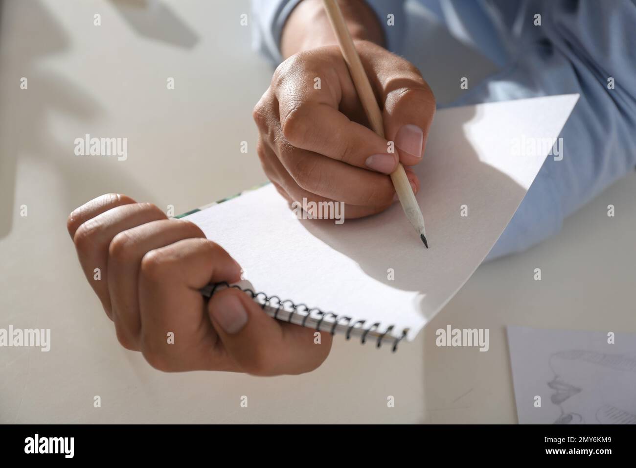 Man drawing with pencil in notepad at table, closeup Stock Photo - Alamy