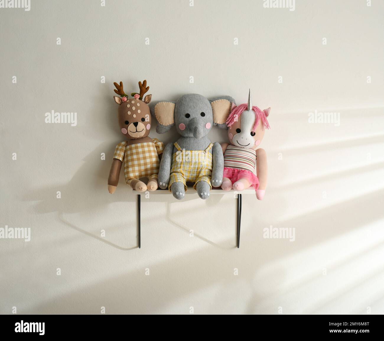 Shelf with cute toys on light wall. Baby room interior element Stock ...