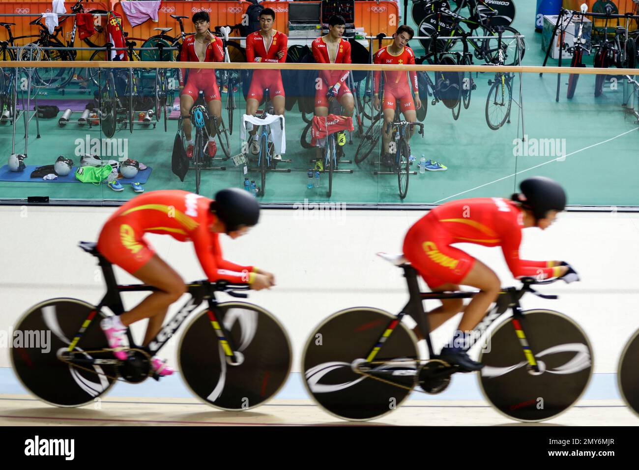 Members of the Chinese men's track watch as a members of the Chinese ...