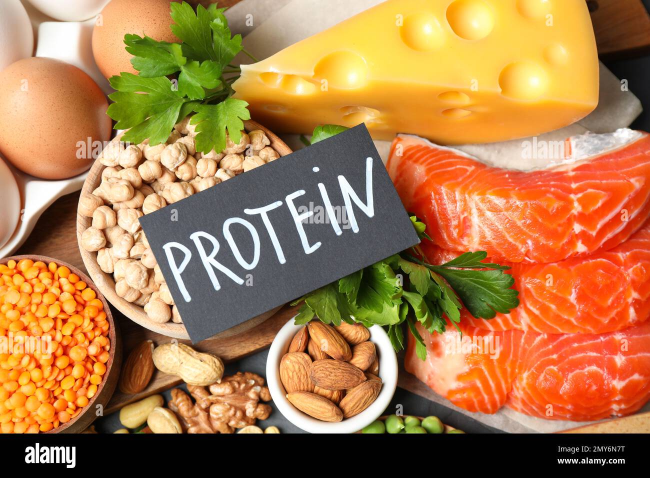 Card with word PROTEIN and different products as background, flat lay ...