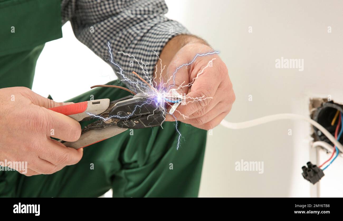 Electrician receiving electric shock while working, closeup Stock Photo ...