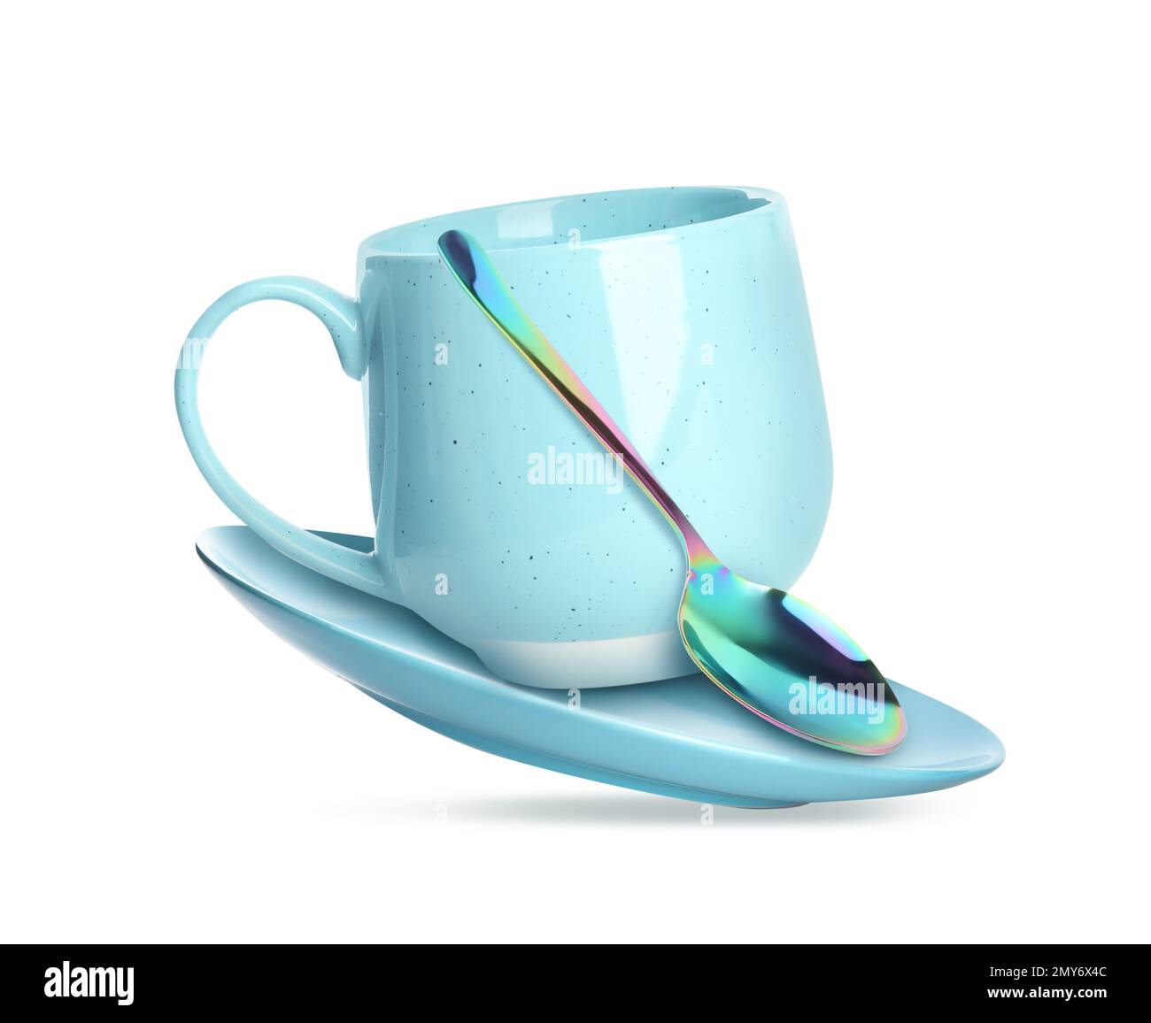 Clean turquoise cup with saucer and teaspoon in flight on white ...