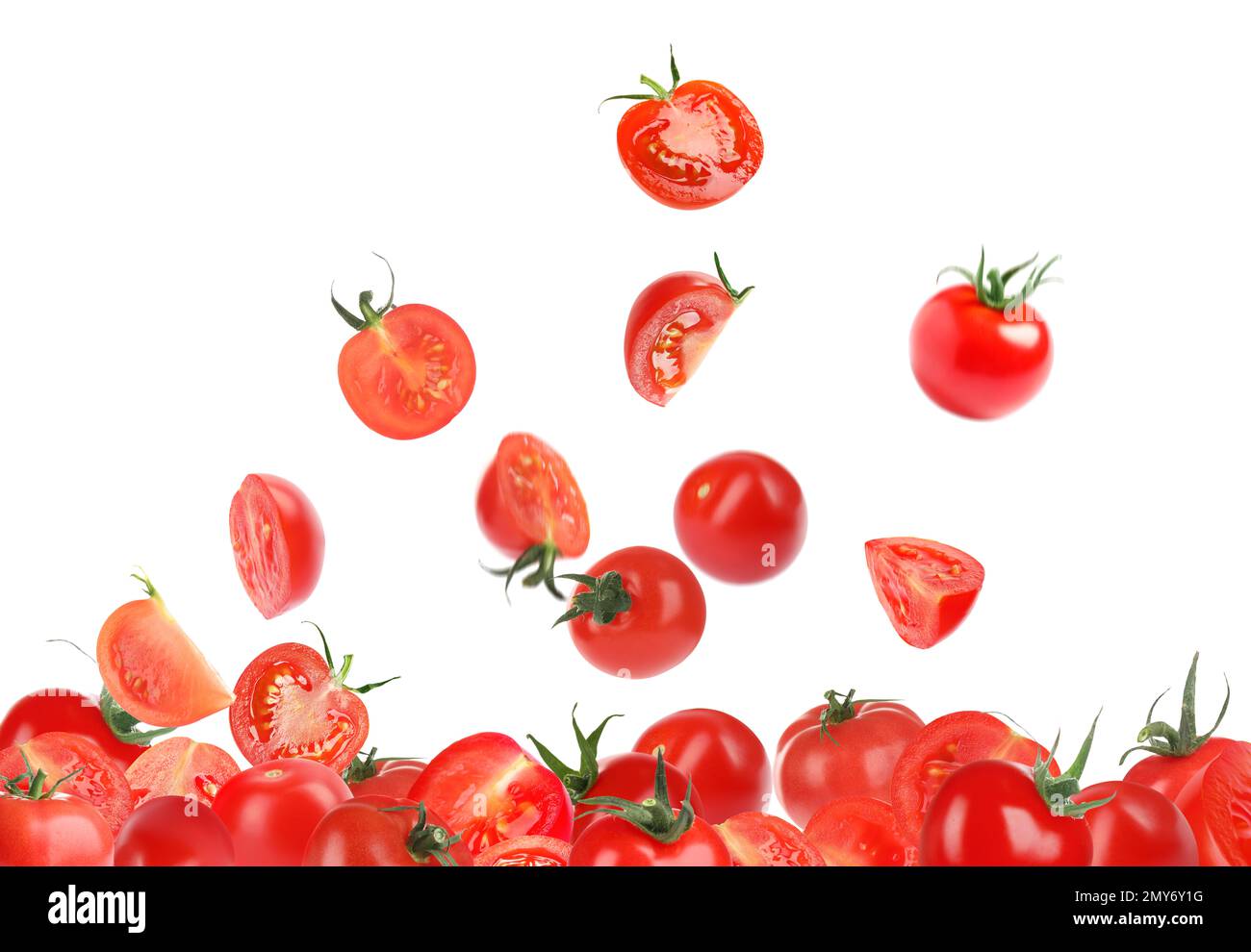 Many cut and whole tomatoes falling on white background Stock Photo - Alamy