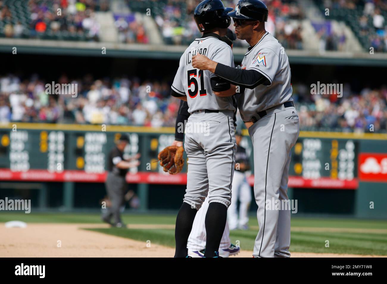 Miami Marlins' Ichiro Suzuki, left is hugged after hitting a triple by ...