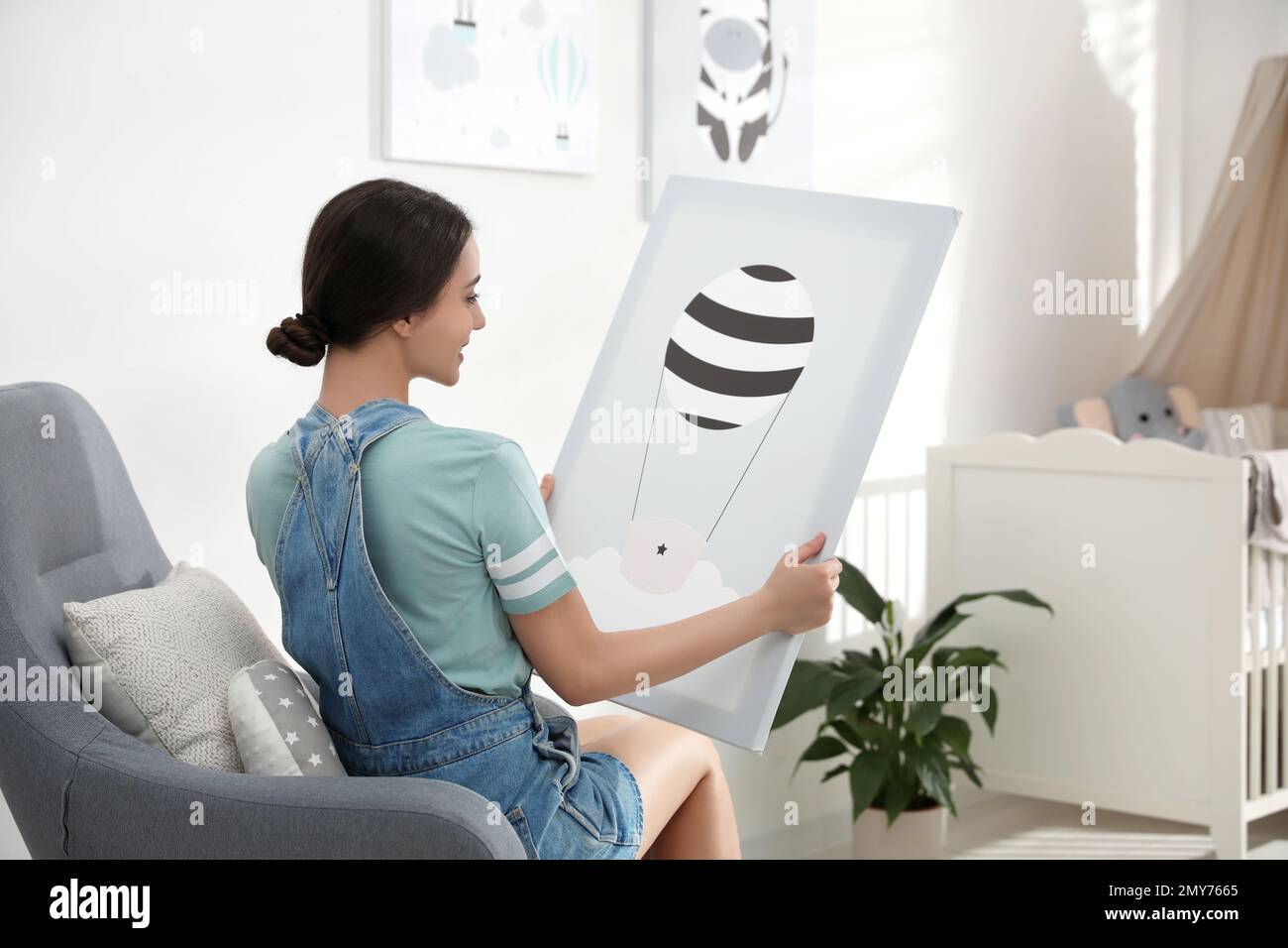 Decorator with picture sitting indoors. Children's room interior design ...