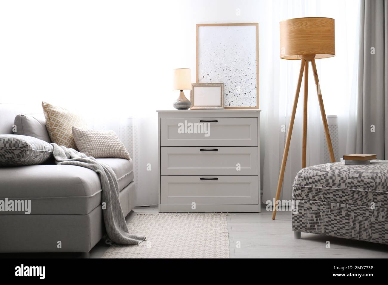 Modern stylish chest of drawers near window in living room. Interior ...