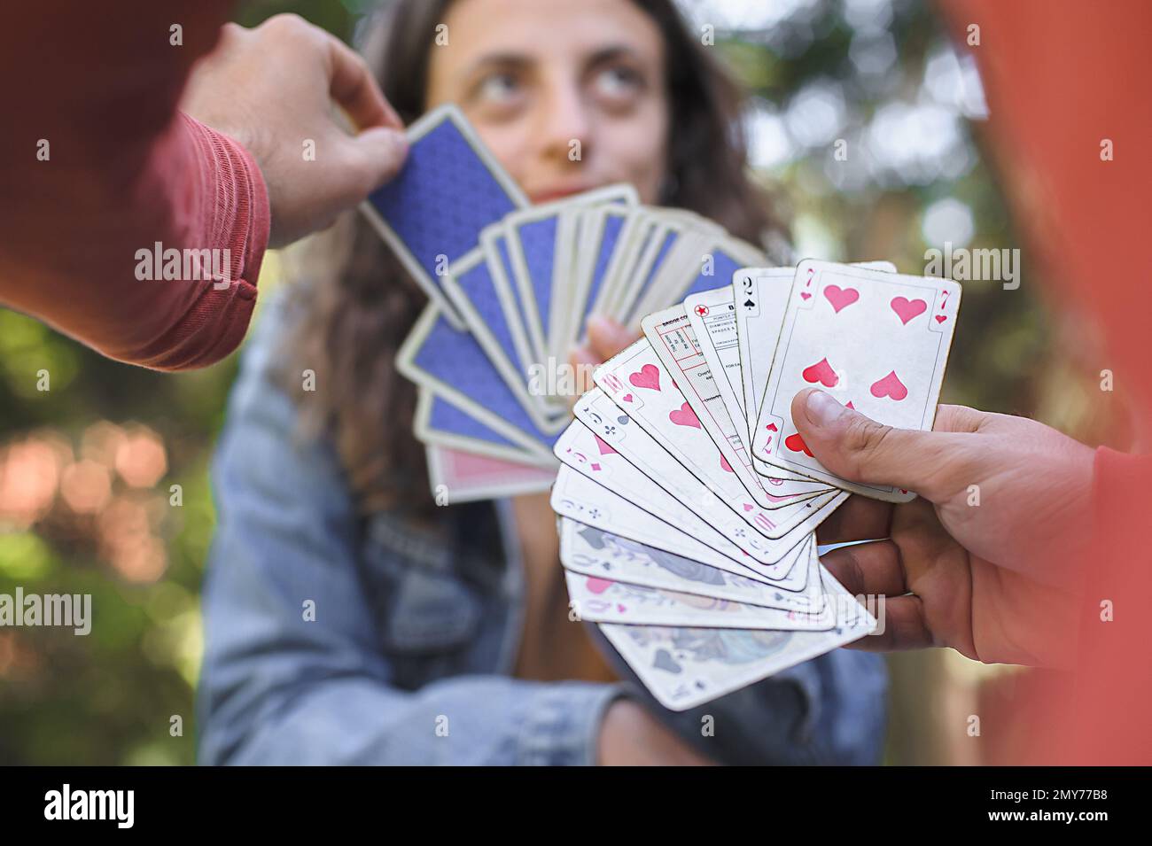 Card playing in a spring garden: Couple are sitting on a table ...