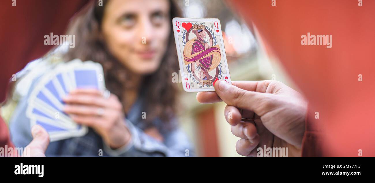 Card playing in a spring garden: Couple are sitting on a table ...
