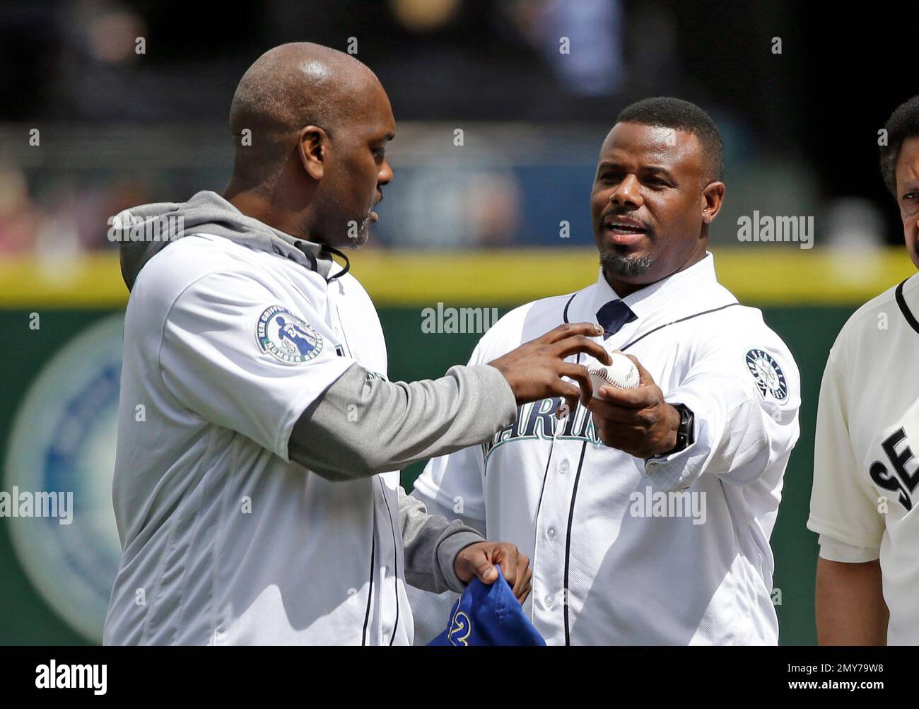Former Seattle Mariners outfielder Ken Griffey Jr., right, hands a ball ...