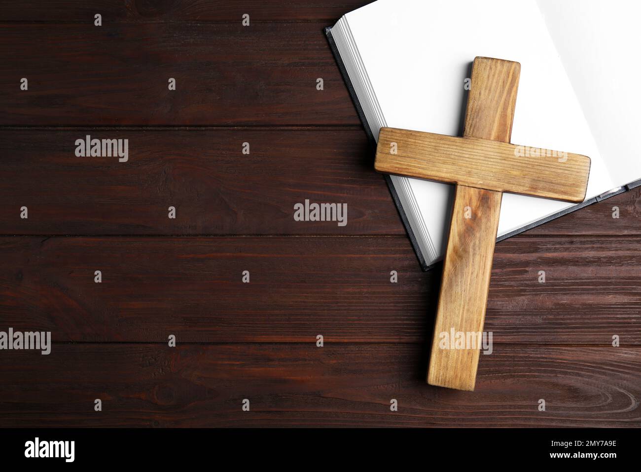 Christian cross and Bible on wooden background, top view with space for ...