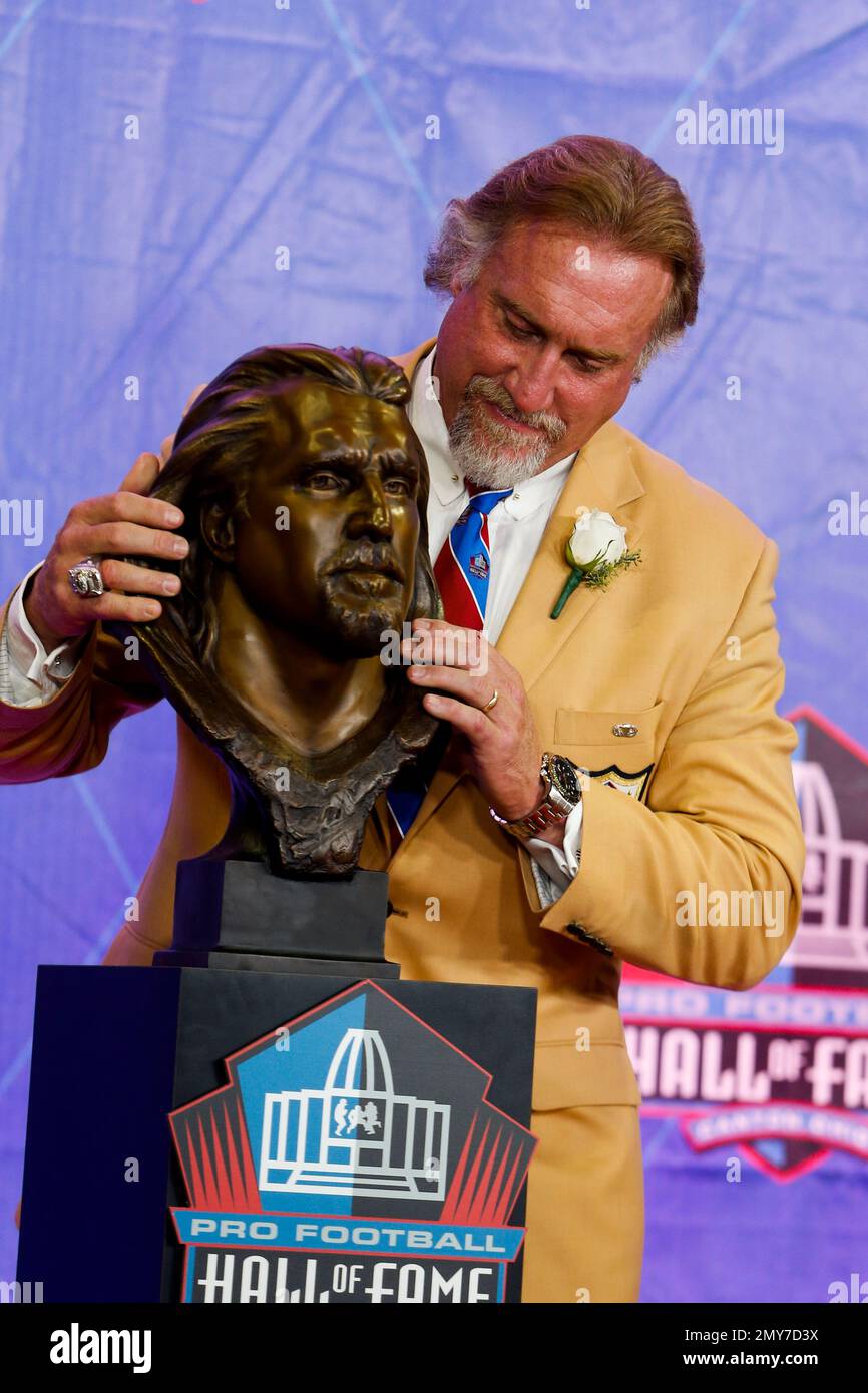 Former NFL player Kevin Greene poses with his bust during an induction ...