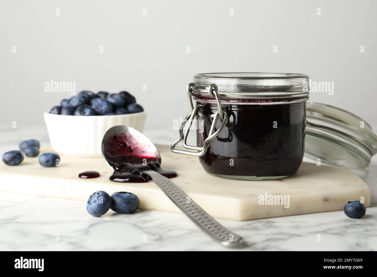 Jar of blueberry jam and fresh berries on white marble table Stock ...