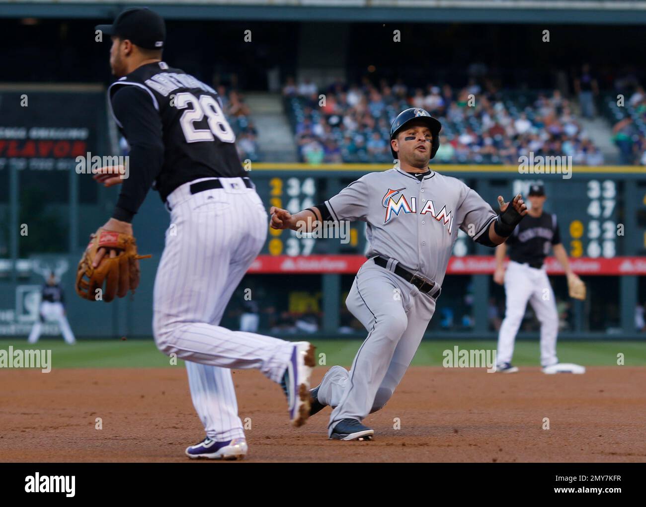 Miami Marlins' Martin Prado, front right, slides safely into third base ...