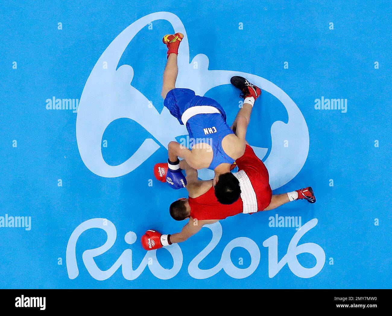 China's Shan Jun in blue fights Tajikistan's Anvar Yunusov during a men ...