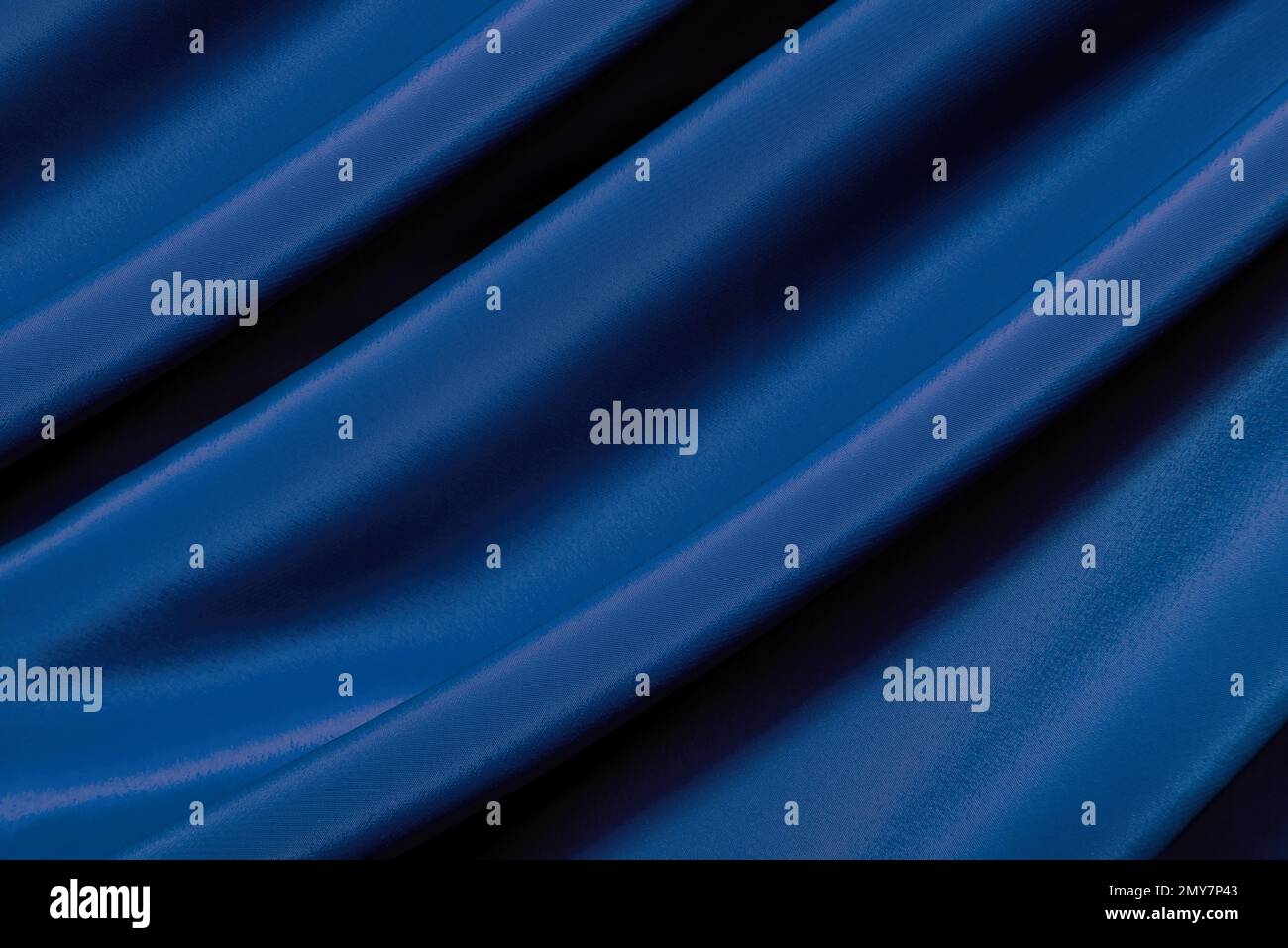 The texture of a luxurious smooth fabric in blue, purple with folds and ...