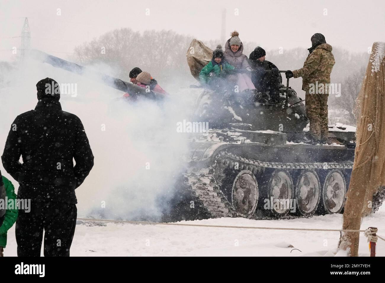 People ride with their children atop a Soviet T-54 tank during a ...