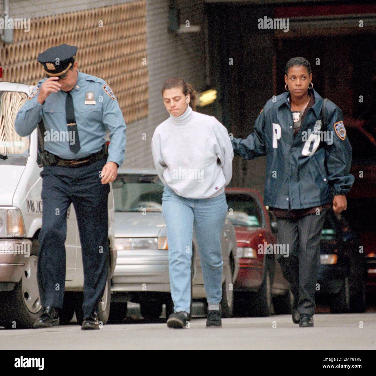 New York City Police officer Justine Fazzini, left, is lead away from ...