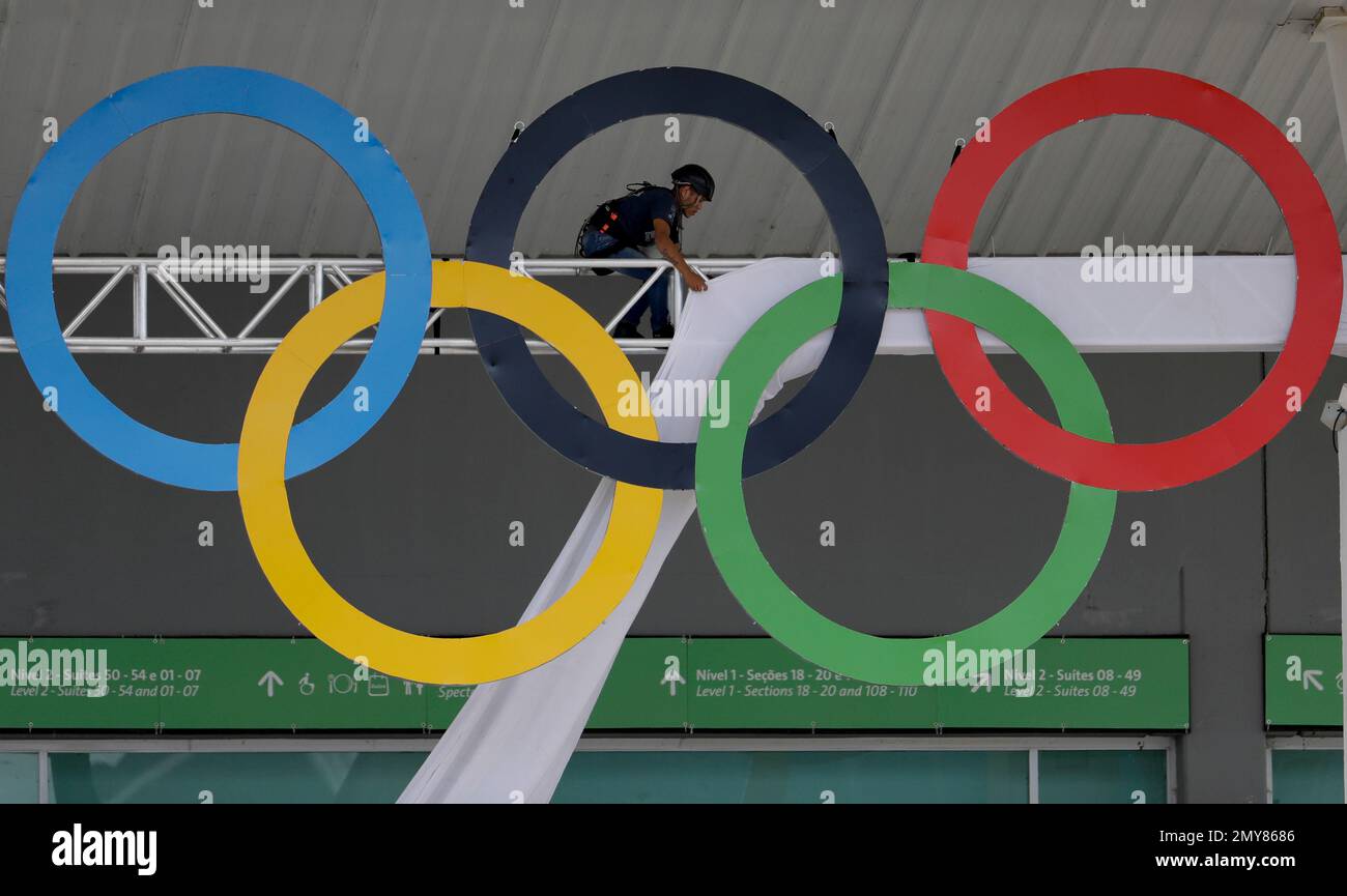 A worker covers the scaffolding holding the Olympic Rings at the ...