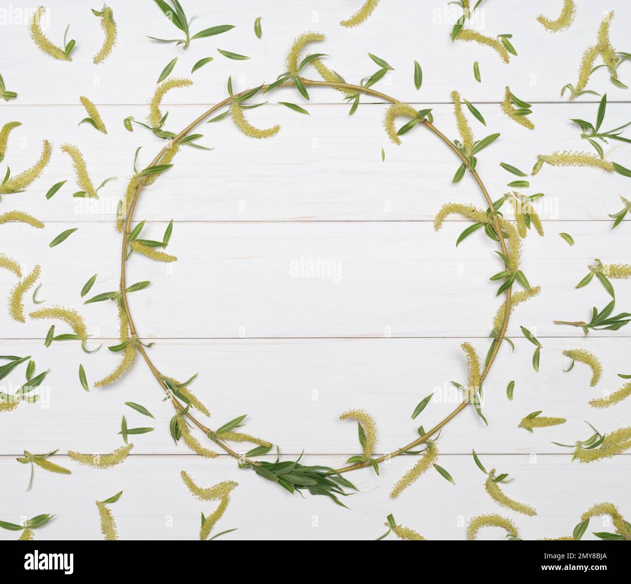 Decorative frame from a branch of a willow tree on a white wooden ...